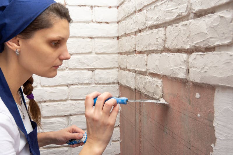 Girl Plasterer Lays on the Wall with Plaster Imitation Brickwork Stock ...