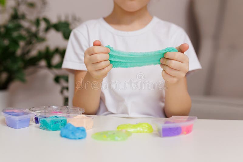 Girl Playing with Different Colors and Textures Slime at Table Stock ...