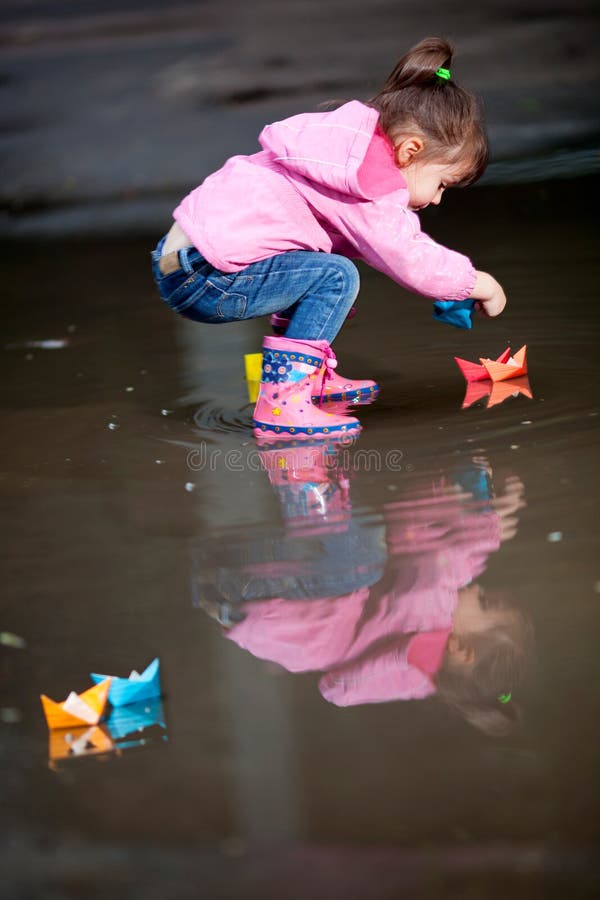 Girl playing in puddle stock photo. Image of happiness - 25184542
