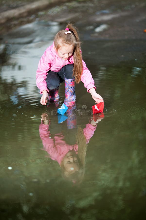 Girls playing in puddle stock photo. Image of sailing - 25184518