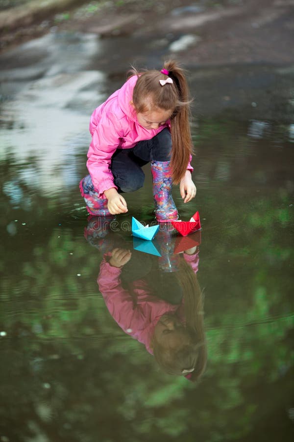 Girls playing in puddle stock photo. Image of sailing - 25184518