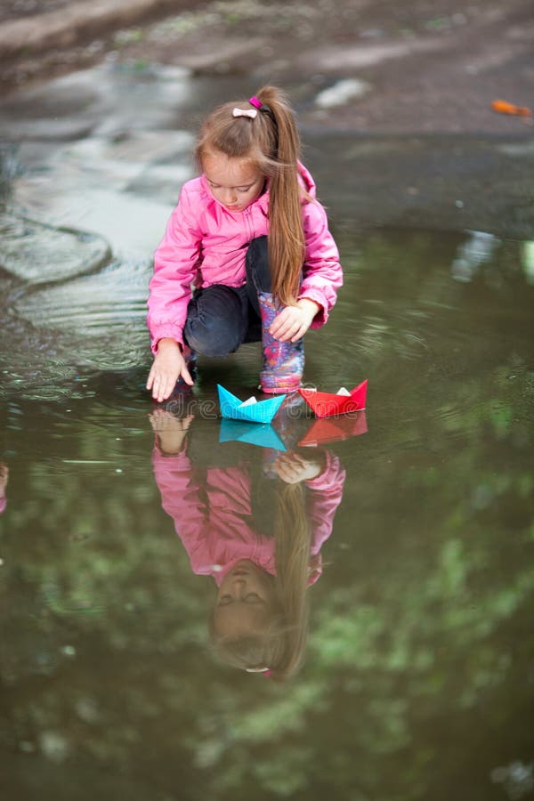 Girls playing in puddle stock photo. Image of sailing - 25184518