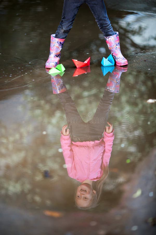 Girls playing in puddle stock photo. Image of sailing - 25184518