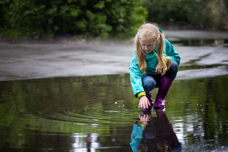 Girl playing in a puddle stock photo. Image of rainy - 92588172