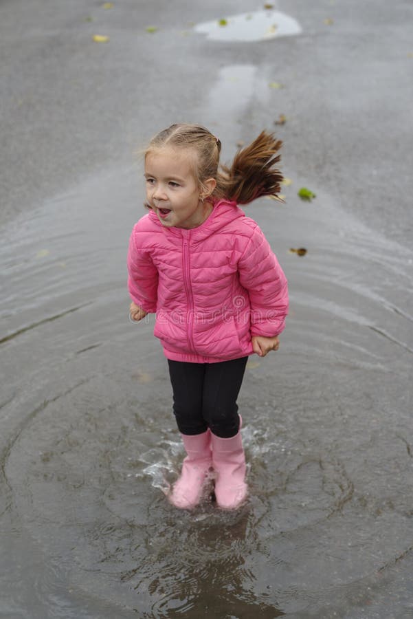 Girl playing in puddle stock photo. Image of happy, city - 371817138