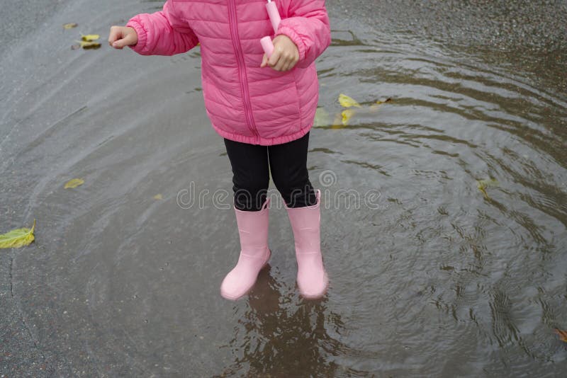 Girl playing in puddle stock image. Image of blonde - 372337965