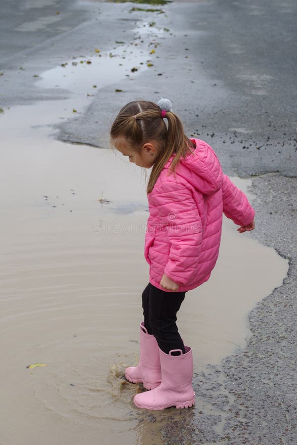 Girl Playing in a Puddle of Water after Rain Stock Image - Image of ...