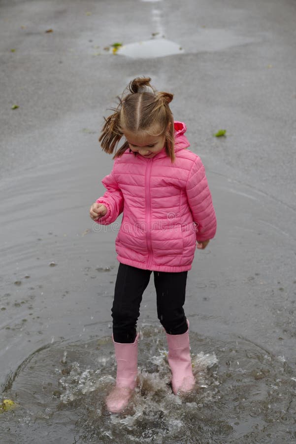 Girl Playing in a Puddle of Water after Rain Stock Photo - Image of ...