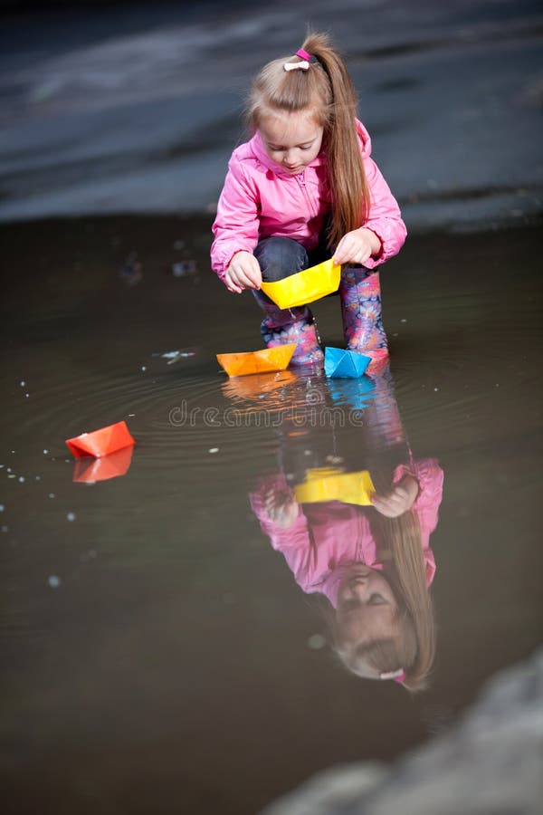 Girls playing in puddle stock photo. Image of sailing - 25184518