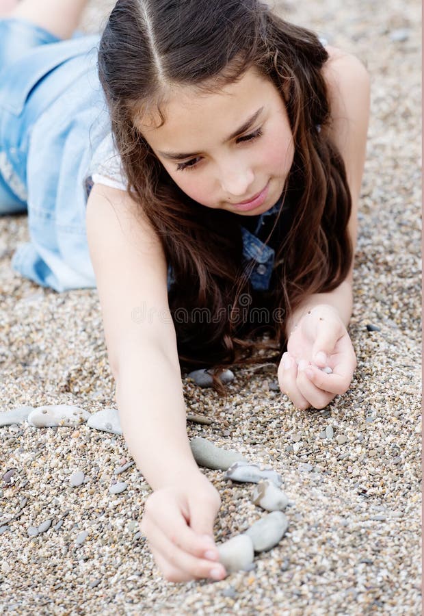 Girl Playing with Stones Lying on the Pebbles Stock Photo - Image of ...