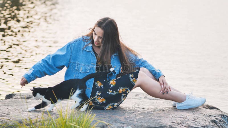 A Girl Plays with a Cat by the Lake. Stock Photo - Image of friends ...
