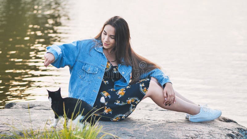 A Girl Plays with a Cat by the Lake. Stock Image - Image of care ...