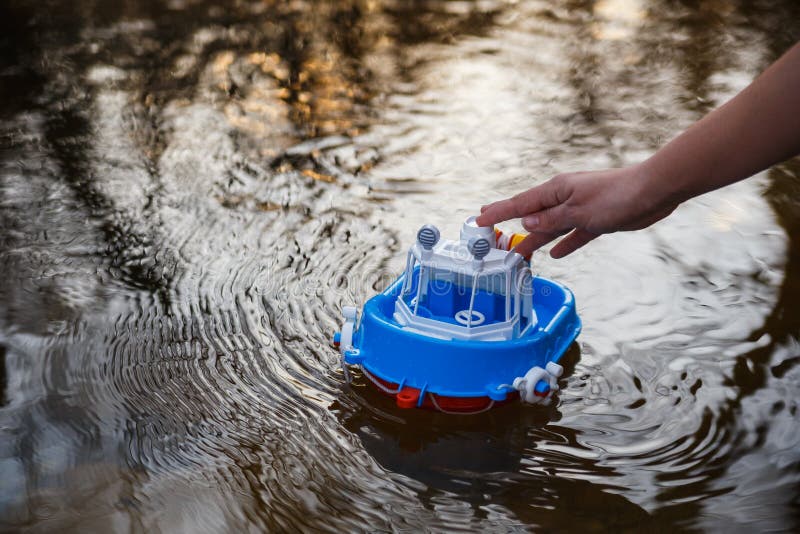 A Small Toy Boat Sails Along a Forest River at Sunset Stock Photo ...