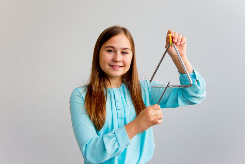 Girl plays a triangle stock image. Image of loud, hands - 110390615