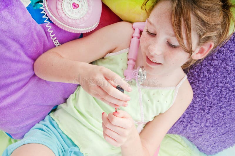 Girl Polishing Nails on Phone Stock Photo - Image of polish, lounging ...