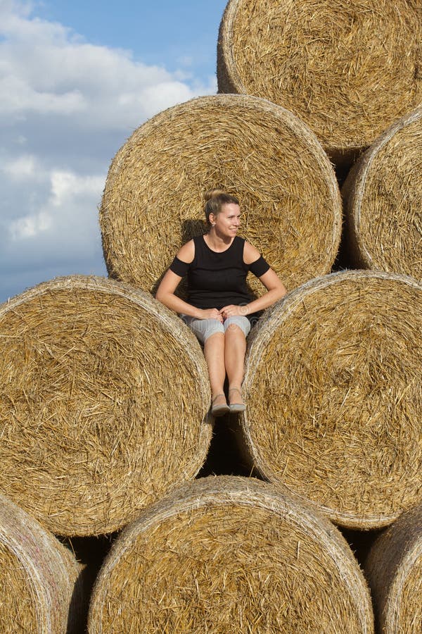 Girl Posing Near a Stack of Straw. Straw Rolls, Stacked in a Pyramid ...