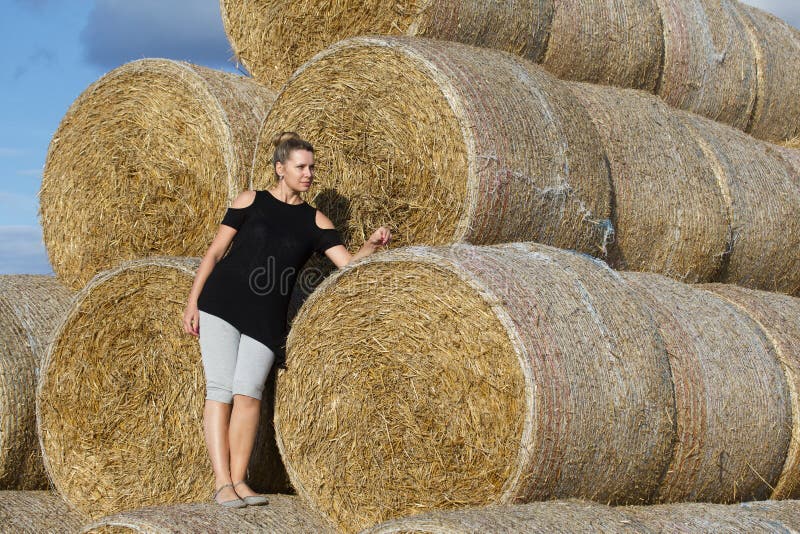 Girl Posing Near a Stack of Straw. Straw Rolls, Stacked in a Pyramid ...