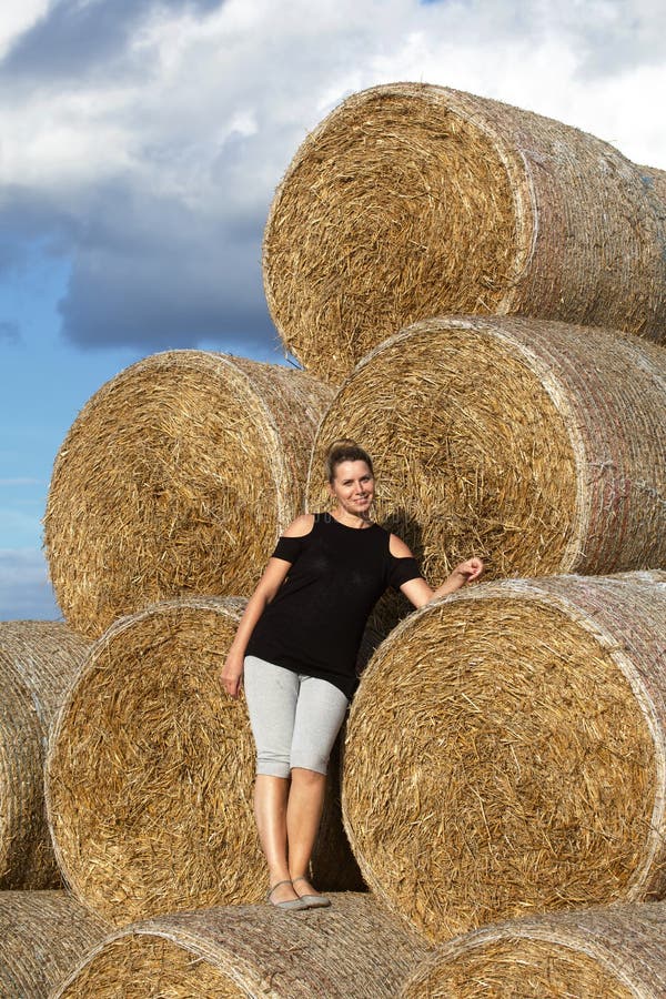 Girl Posing Near a Stack of Straw. Straw Rolls, Stacked in a Pyramid ...