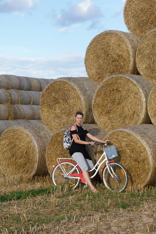 Girl Posing Near a Stack of Straw. Sits on a Bike Stock Photo - Image ...