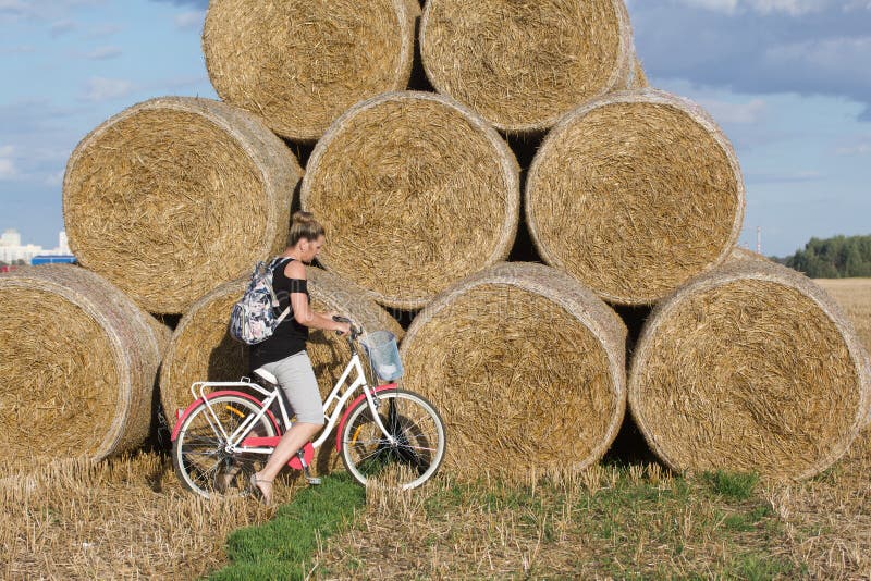Girl Posing Near a Stack of Straw. Sits on a Bike Stock Photo - Image ...