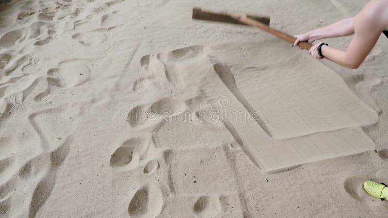 Girl Raking the Sand after a Long Jump in the Sandpit Stock Video ...