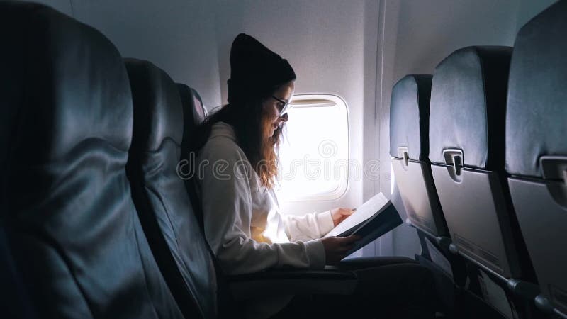 Girl Read Book during the Flight Stock Footage - Video of computer ...