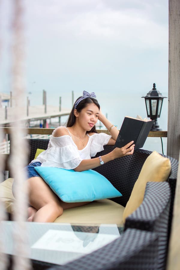 Girl Reading Book on the Balcony with Seaside View Stock Photo - Image ...