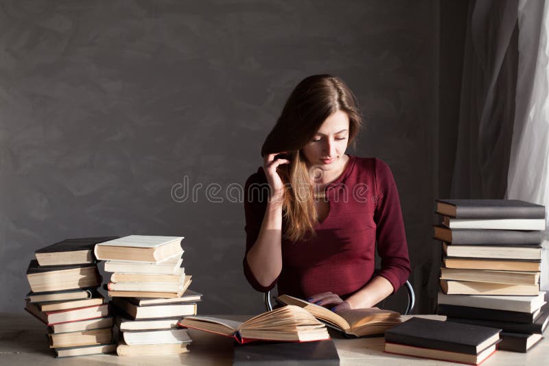 Girl Reading a Book in the Library is Preparing for the Exam Stock ...