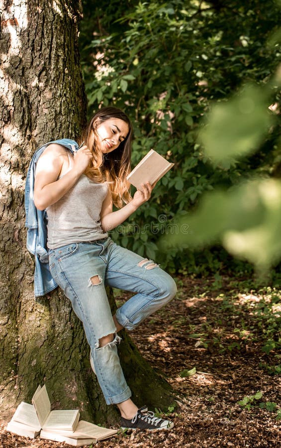 Girl Reading a Book Near a Tree Stock Photo - Image of browsing, autumn ...
