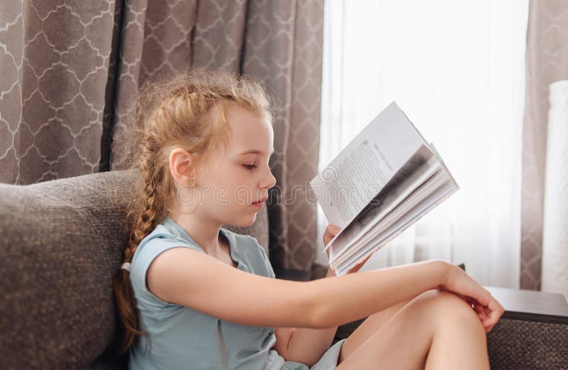Girl Reading a Book for School Program Sitting on the Couch. the Theme ...