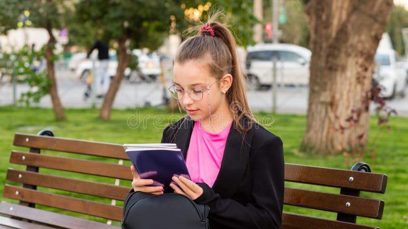 Girl Reading Book while Sitting on Park Bench Stock Photo - Image of ...
