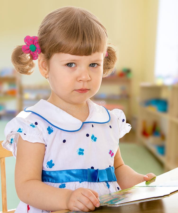 Girl Reading a Book while Sitting at Table. Stock Image - Image of cute ...
