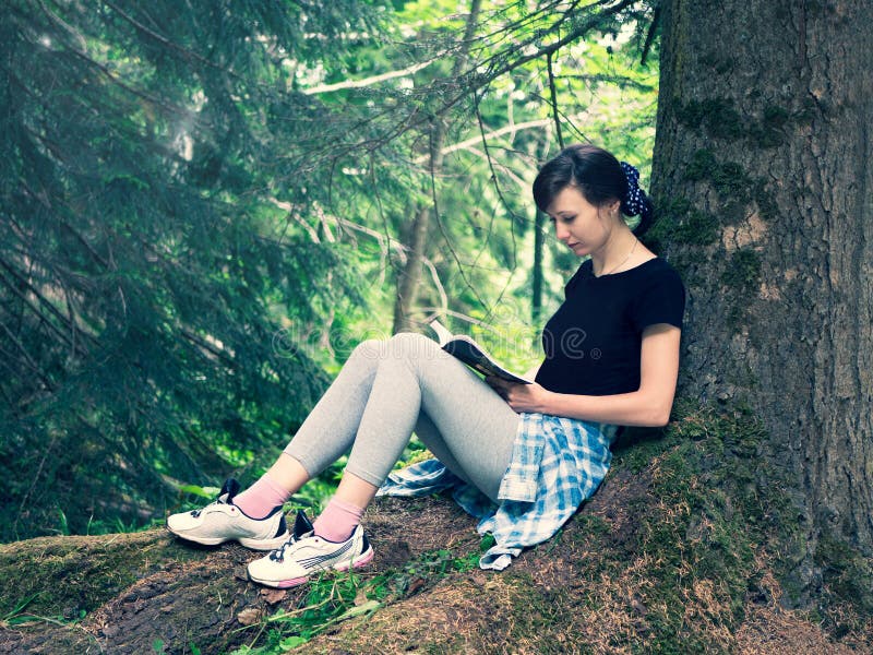 Girl Reads a Book in Nature Under Shadow of Pine Tree Stock Image ...