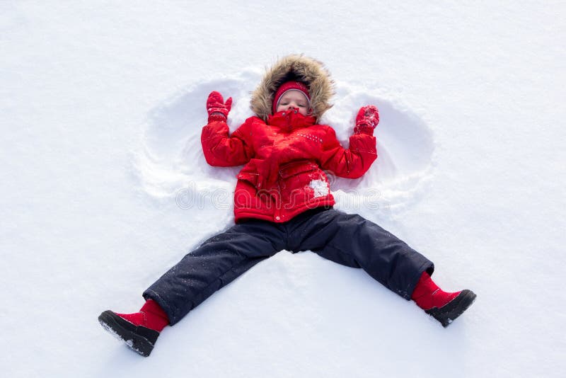 Girl in a Red Jacket Makes Snow Angel Stock Photo - Image of person ...