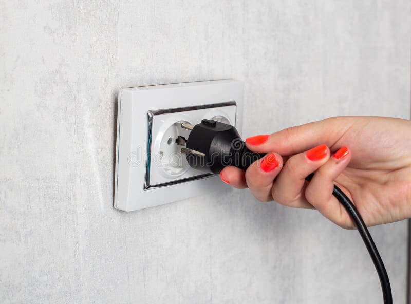 The Girl Removes the Electrical Plug from the Socket and Breaks the ...
