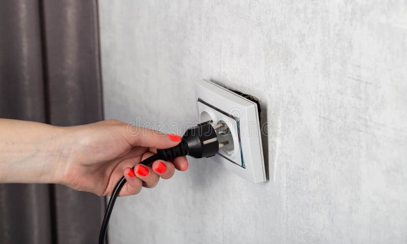 The Girl Removes the Electrical Plug from the Socket and Breaks the ...