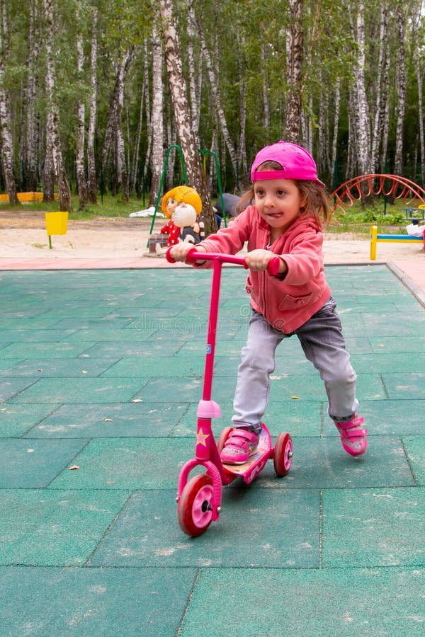 Girl Riding a Scooter on the Street Stock Image - Image of face, park ...
