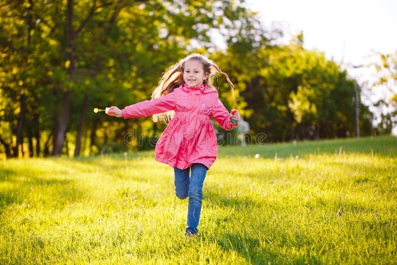 The Girl Run and Play with Soap Bubbles. Stock Photo - Image of ...