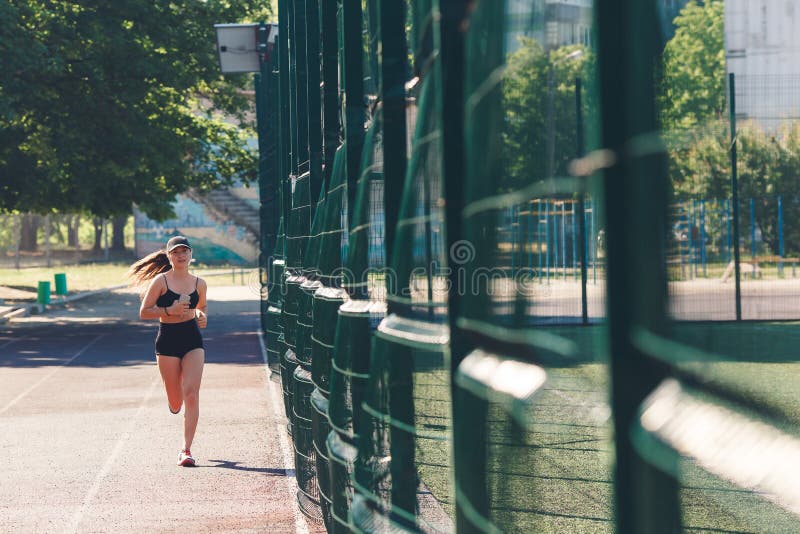 Girl Runs Along the Track at the Stadium. Cardio Workout. Stock Photo ...