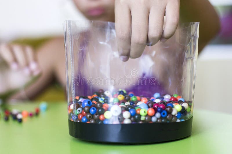 Girl`s Hand Stringing Beads on a String. Needlework and Craft Stock ...