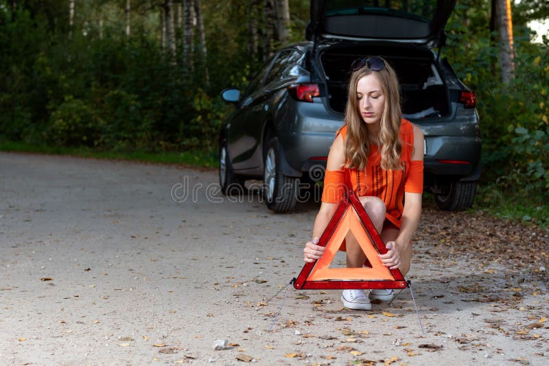 Girl Sets a Triangle in Back of Broken Car Stock Photo - Image of girl ...