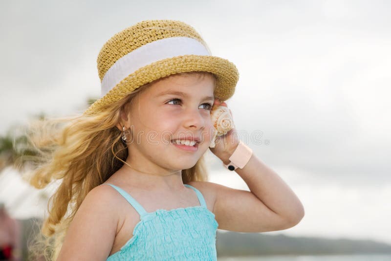 Girl with a shell stock photo. Image of listen, blond - 4976804