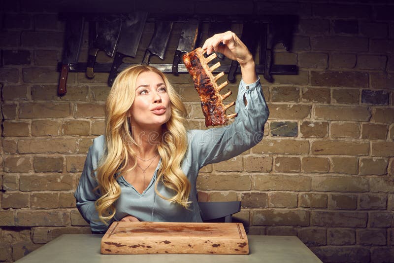 The Girl Eats Meat in a Restaurant. Expressive Stock Image - Image of ...