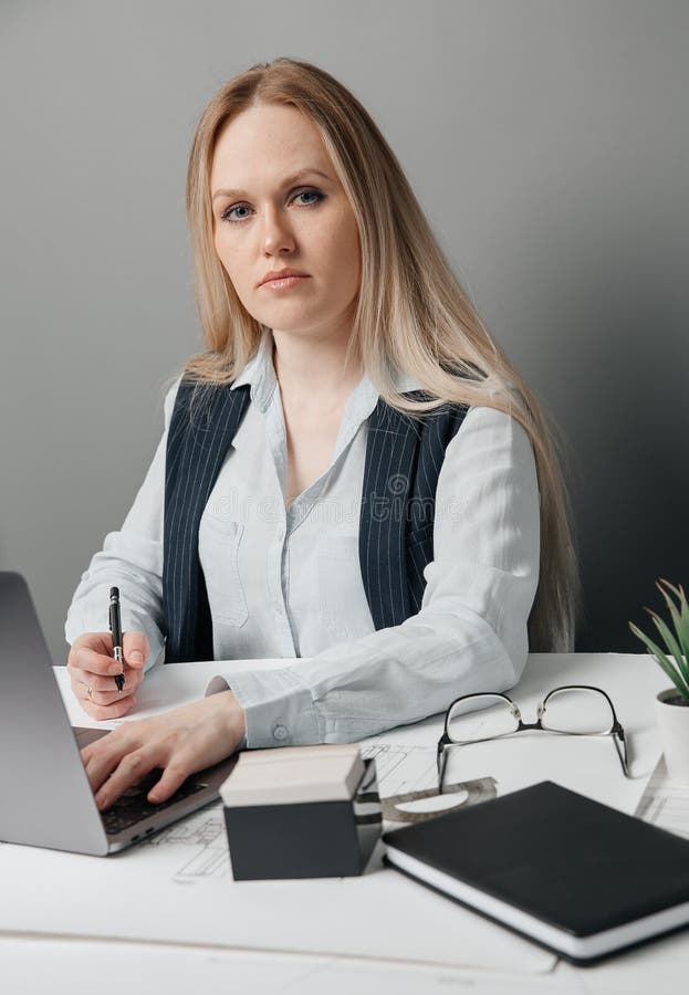 Young Beautiful Business Girl Takes Some Notes in a Notebook while ...