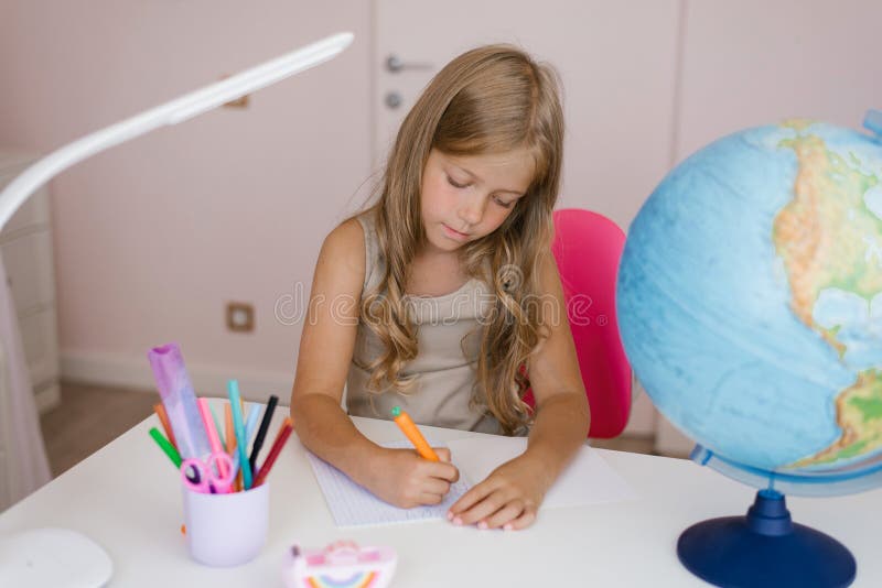 Girl Sits at Home at a Table and Write in a Notebook, Completing a ...