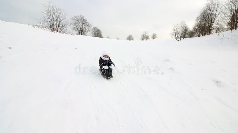 The Girl Sits on a Sled To Ride To the Bottom of the Hill. Slides Down ...