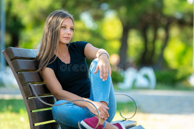 Girl Sitting on a Bench in the Park, Close-up Stock Photo - Image of ...