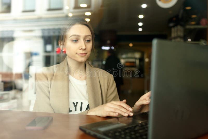 Girl Sitting at a Cafe Table with a Laptop Computer Stock Photo - Image ...