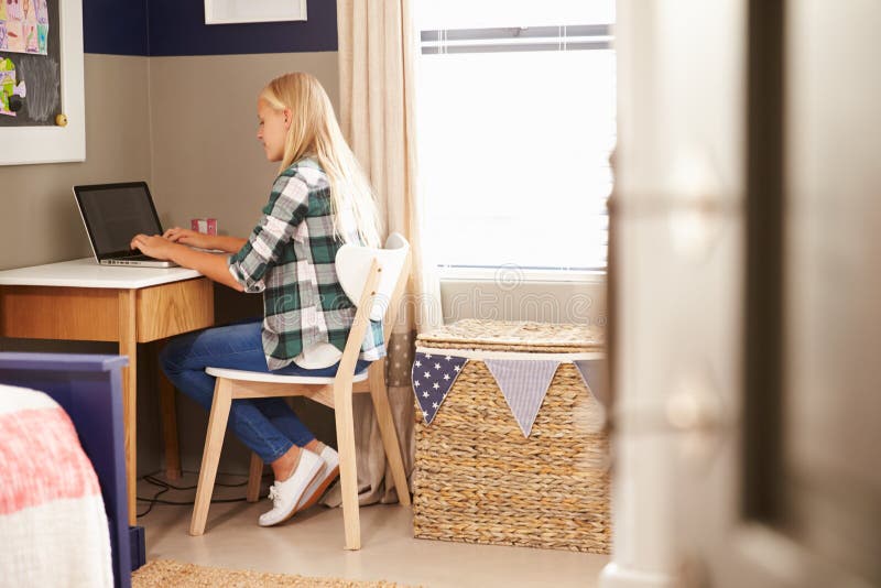 Girl Sitting at a Desk in Her Bedroom Using Laptop Stock Photo - Image ...
