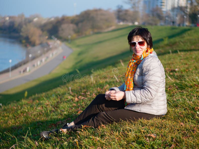Girl Sitting on Grass in Autumn Outdoors Stock Photo - Image of looking ...